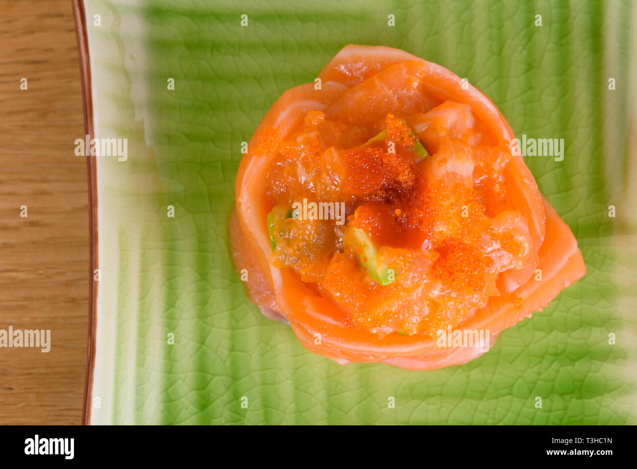 salmon sashimi with caviar and avocado served on a plate, seen from the ...