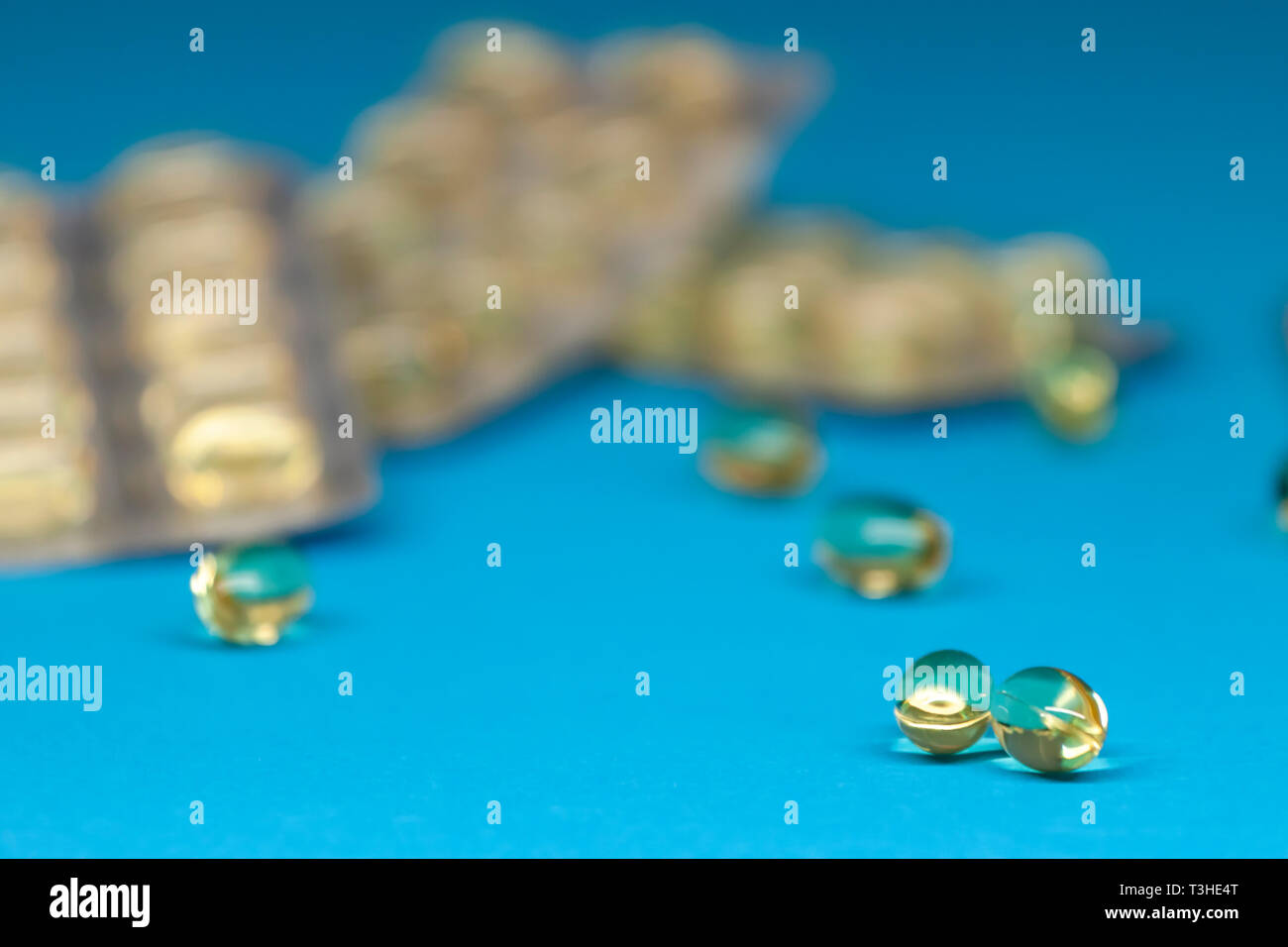 fish oil capsules blisters on blue background Stock Photo - Alamy