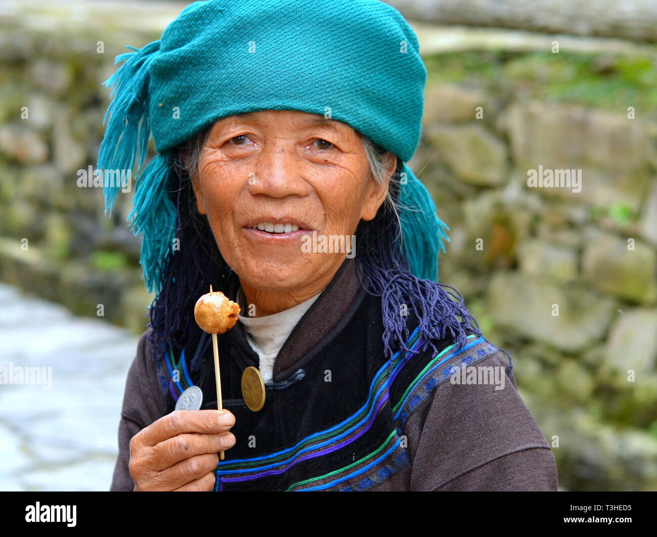 Elderly Hani woman (Chinese ethnic minority) wears a black-and-blue ...