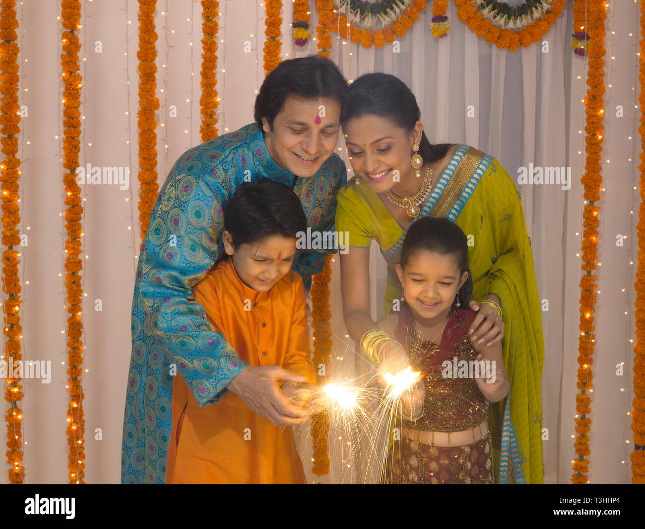 PORTRAIT OF AN INDIAN FAMILY OF FOUR DRESSED IN FORMAL CLOTHES ON A ...