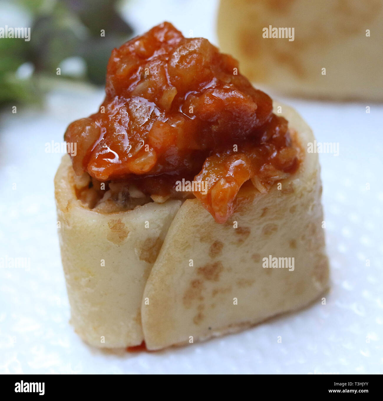 Chicken wrap appetizers covered with tomato, roasted pepper and herbs ...