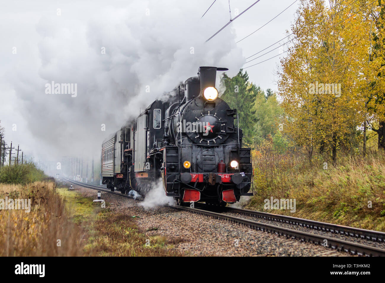 Old Russian locomotive on the railway. Old black locomotive. Smoke from ...