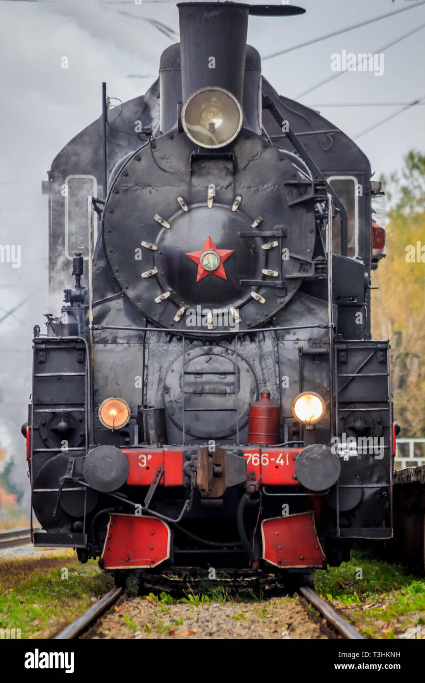 Old Russian locomotive on the railway. Old black locomotive. Smoke from ...