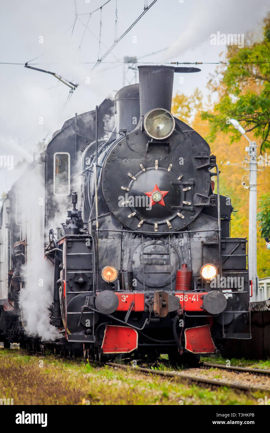 Old Russian locomotive on the railway. Old black locomotive. Smoke from ...