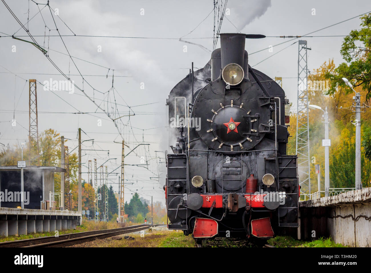 Old Russian locomotive on the railway. Old black locomotive. Smoke from ...