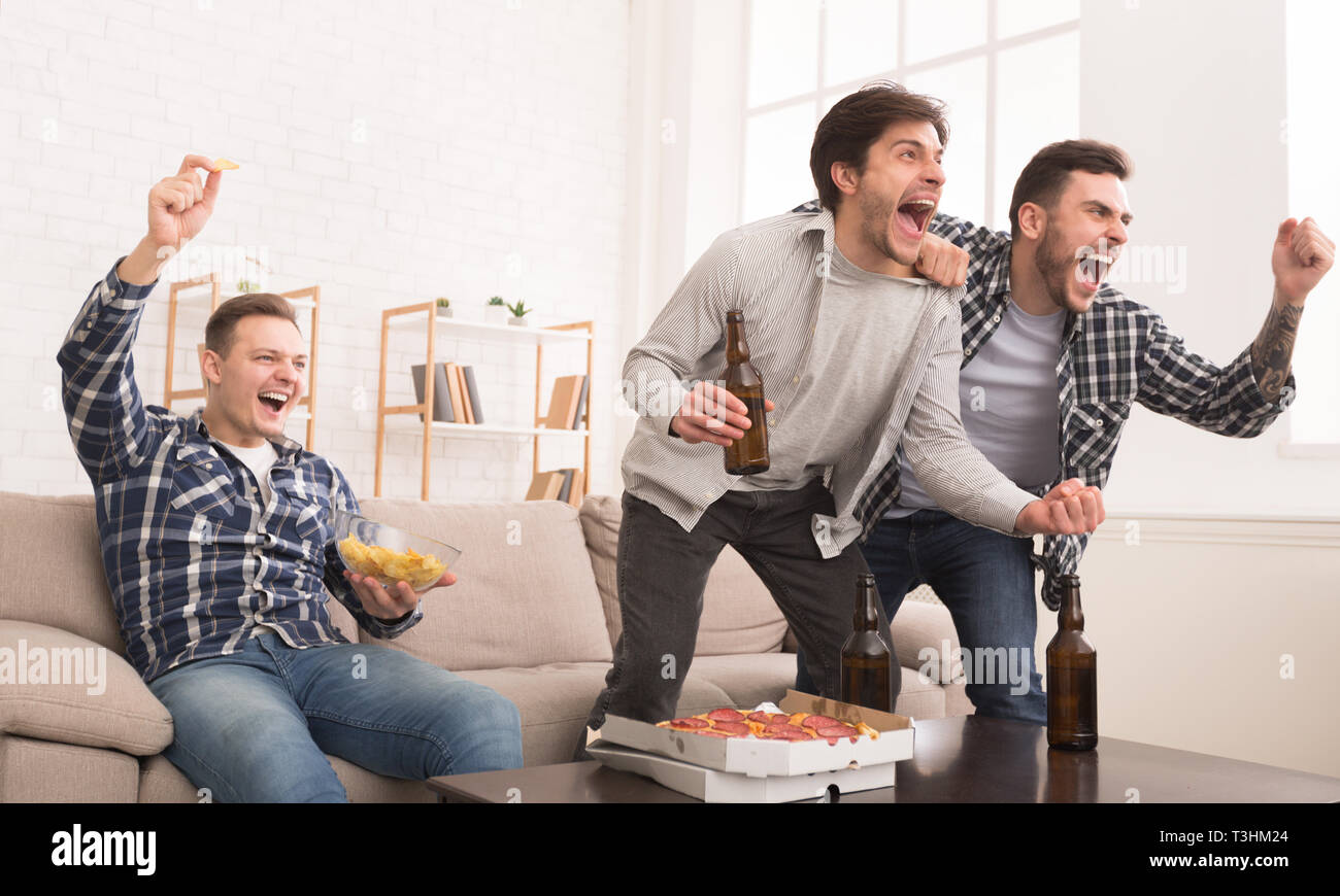 Happy football fans watching soccer on tv and celebrating victory Stock ...