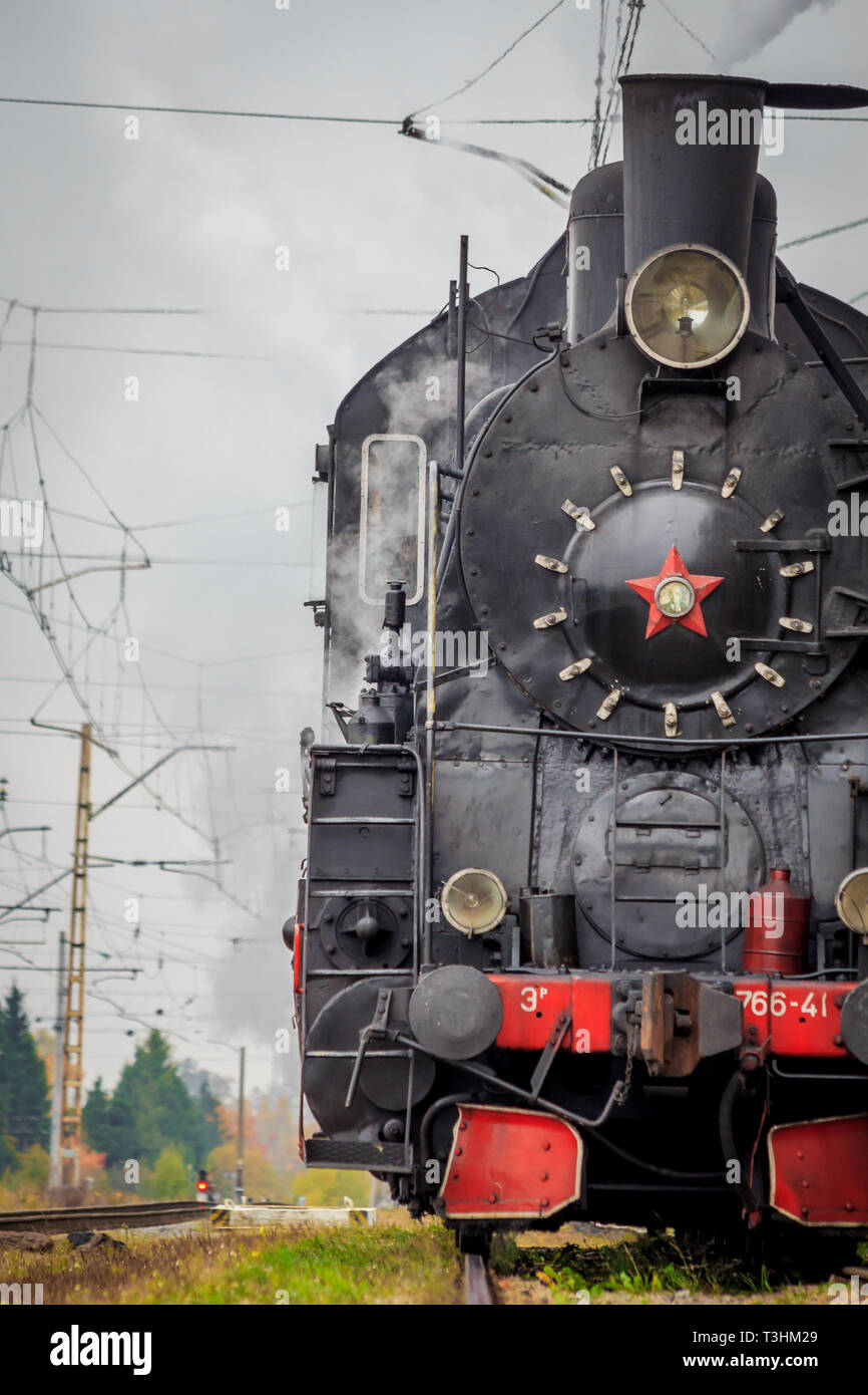 Old Russian locomotive on the railway. Old black locomotive. Smoke from ...