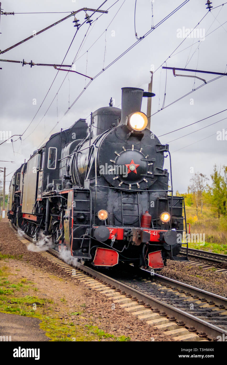 Old Russian locomotive on the railway. Old black locomotive. Smoke from ...