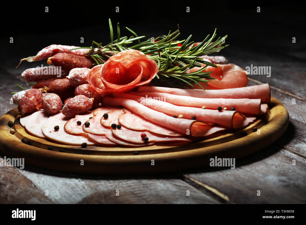 Food tray with delicious salami, pieces of sliced ham, sausage and ...