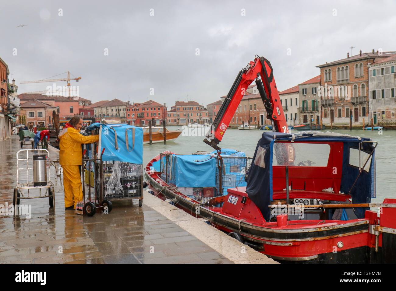 Loading a work boat in Venice Stock Photo - Alamy