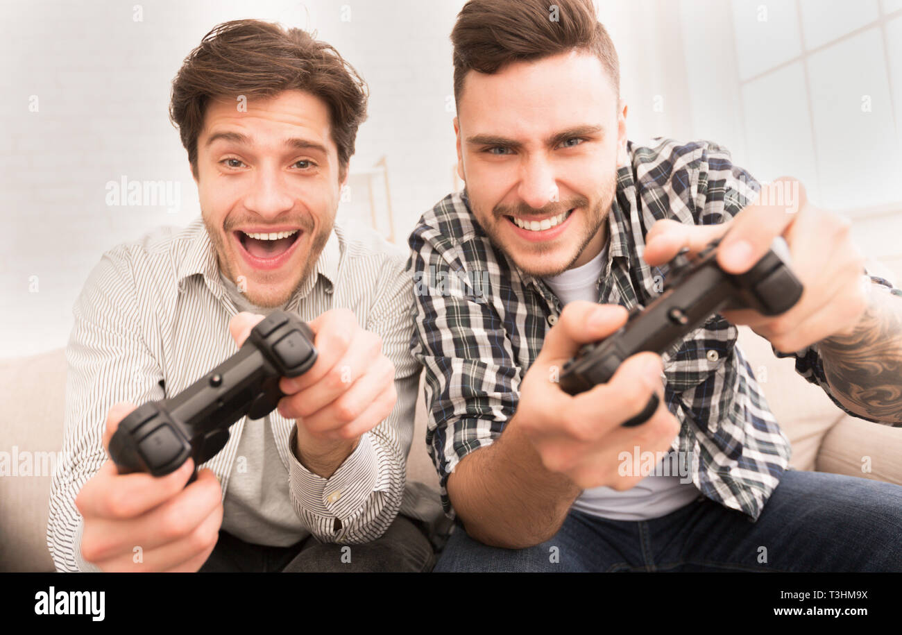 Gamers. Happy guys playing video games at home Stock Photo - Alamy