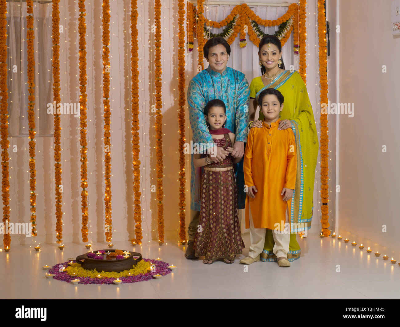 PORTRAIT OF AN INDIAN FAMILY OF FOUR CELEBRATING THE FESTIVAL OF DIWALI ...