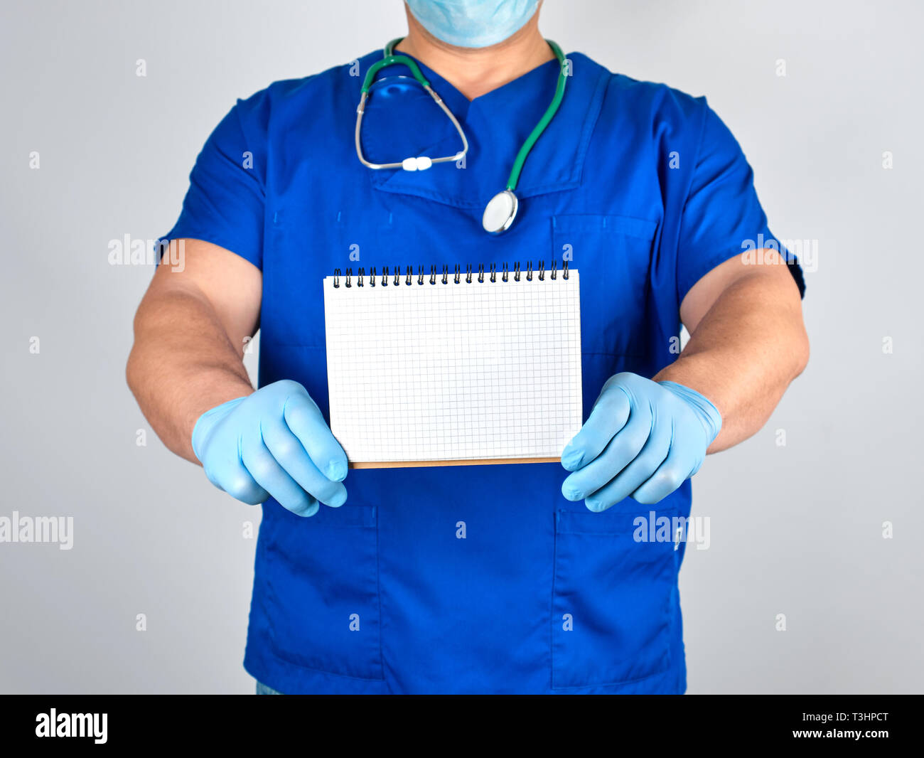 doctor in blue uniform and sterile latex gloves holding open blank ...