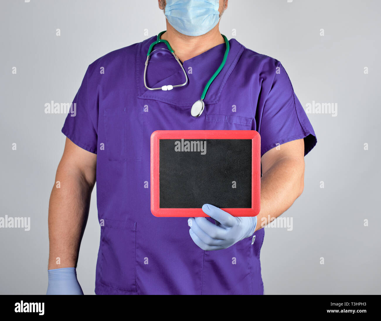 doctor in uniform and latex sterile gloves holding a blank black frame ...
