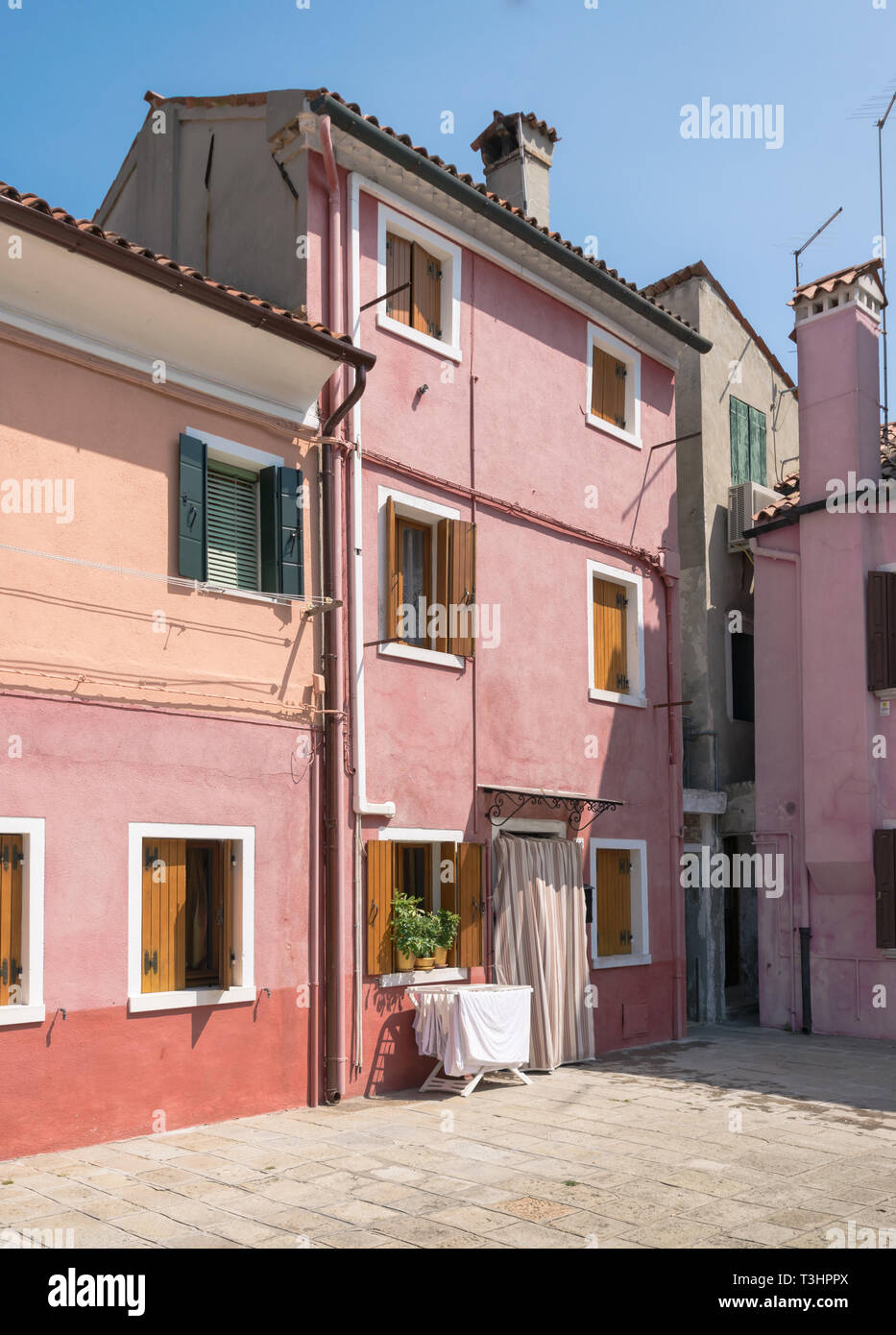 Typical southern Italian house painted in pink on a sunny summer day ...