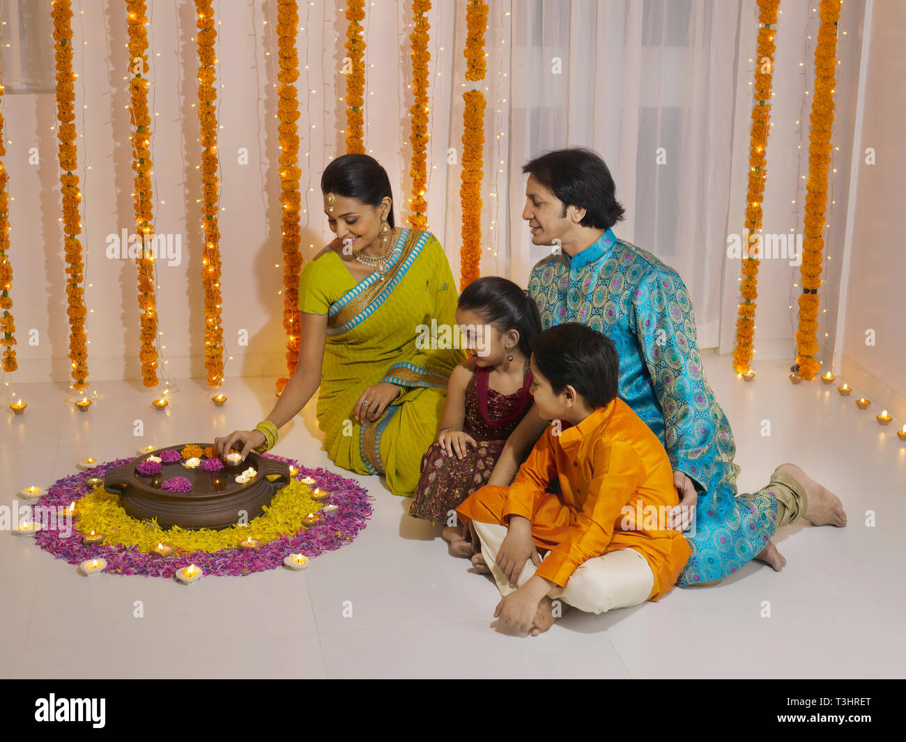 PORTRAIT OF AN INDIAN FAMILY OF FOUR CELEBRATING THE FESTIVAL OF DIWALI ...