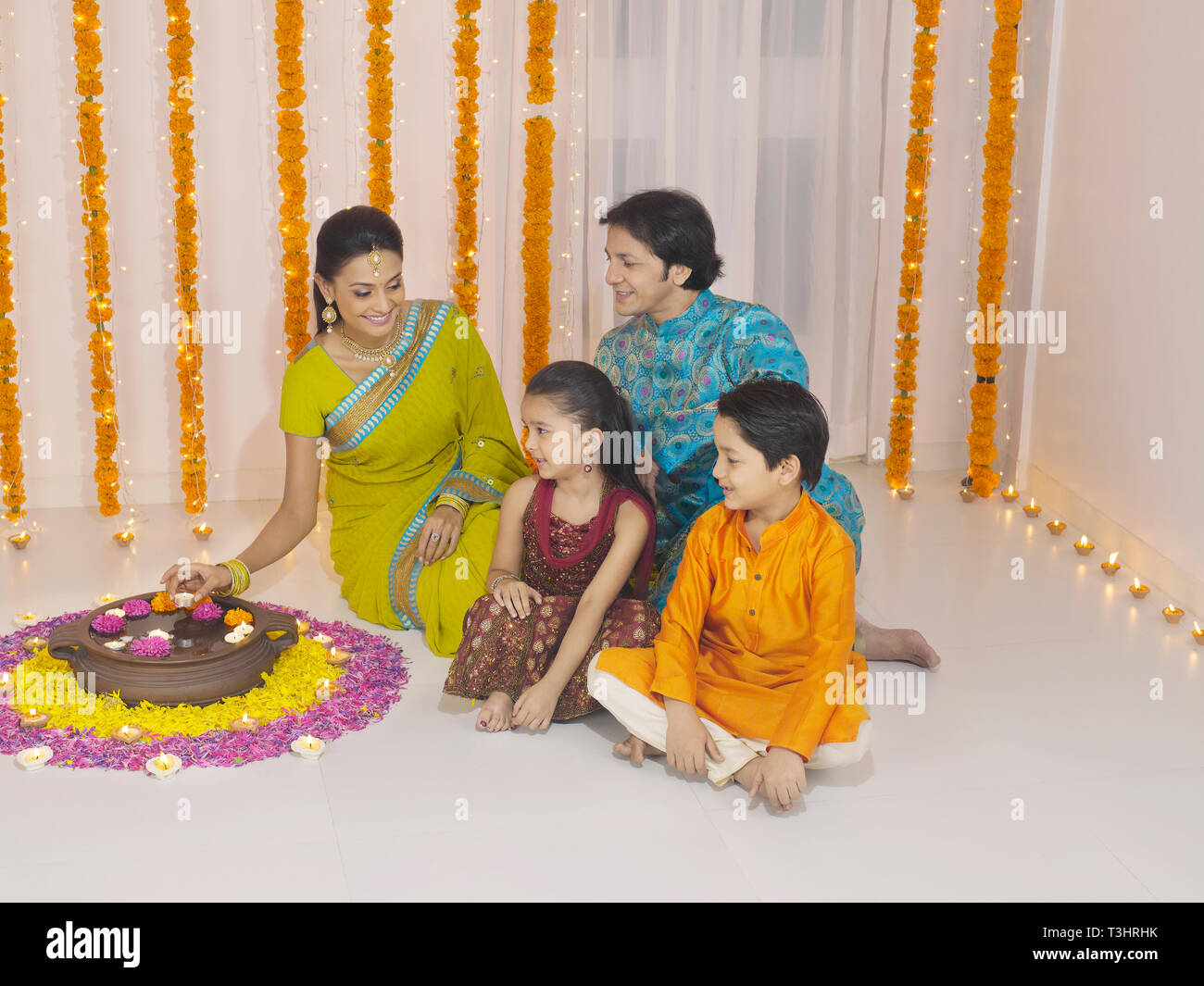 PORTRAIT OF AN INDIAN FAMILY OF FOUR CELEBRATING THE FESTIVAL OF DIWALI ...