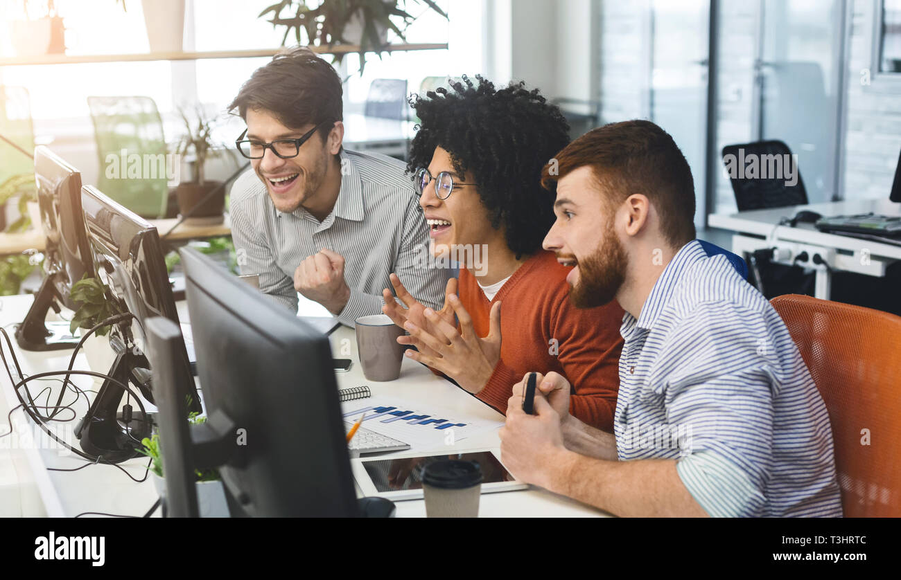 Three young men enjoying good coding job on computer Stock Photo - Alamy