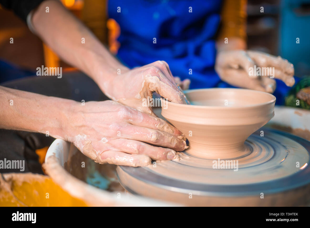 Traditional pottery making, man teacher shows the basics of pottery in ...