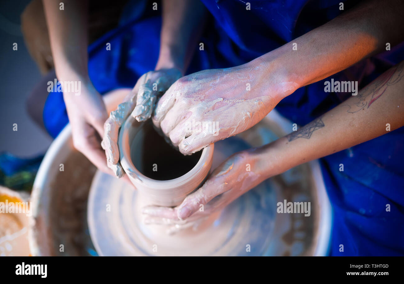 Hands of potter and his female student. Man and woman working together ...