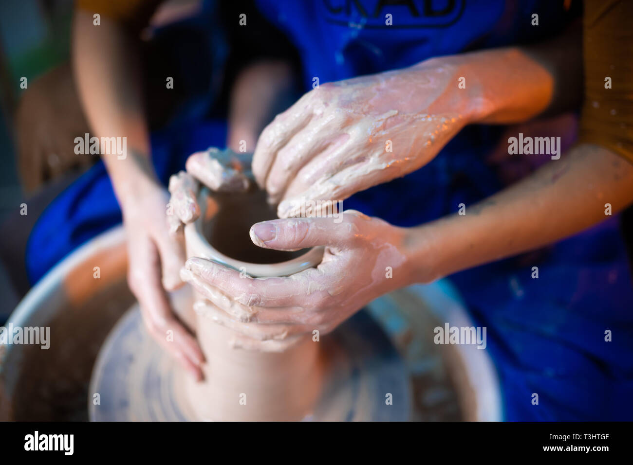 Hands of potter and his female student. Man and woman working together ...