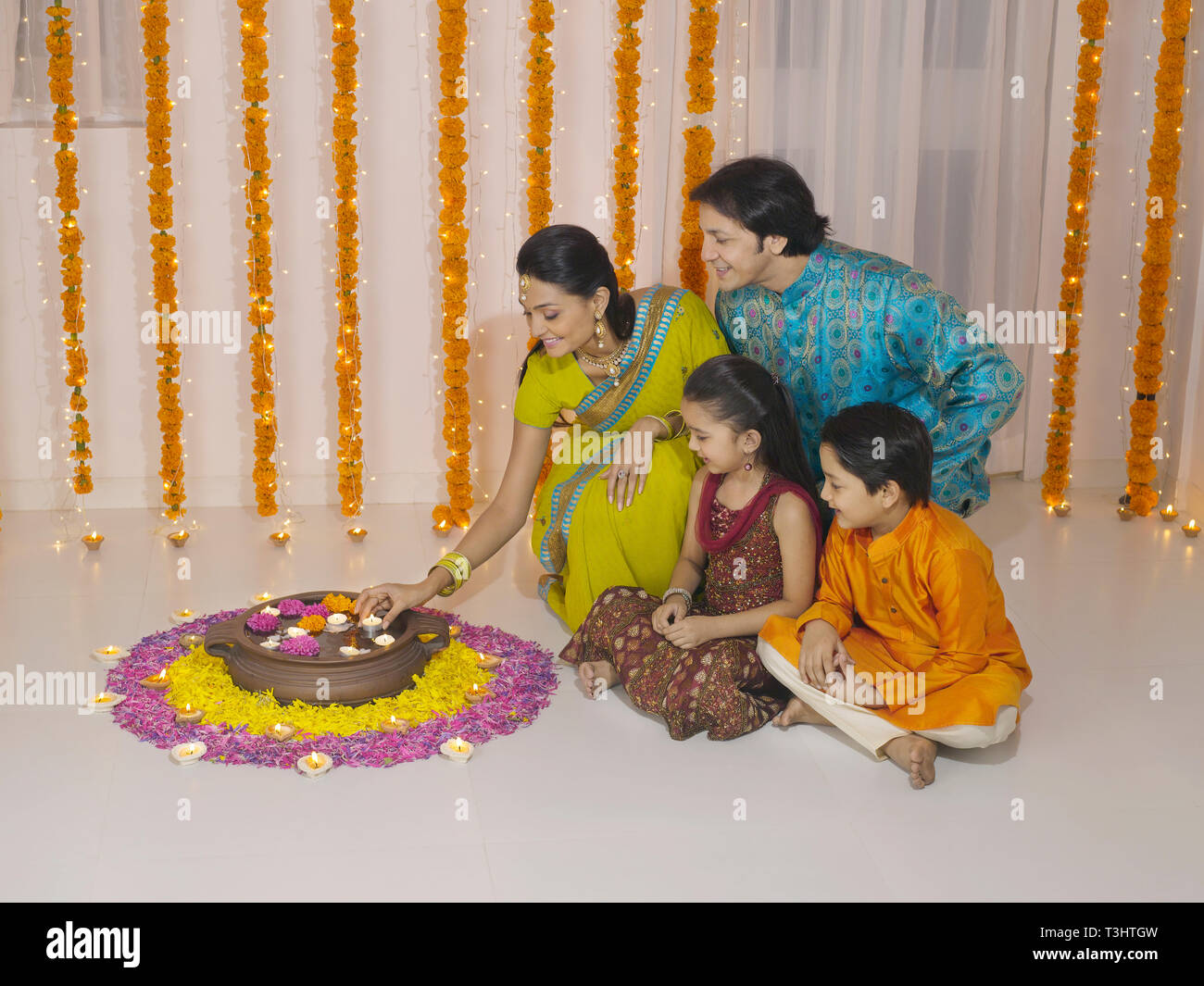 PORTRAIT OF AN INDIAN FAMILY OF FOUR CELEBRATING THE FESTIVAL OF DIWALI ...