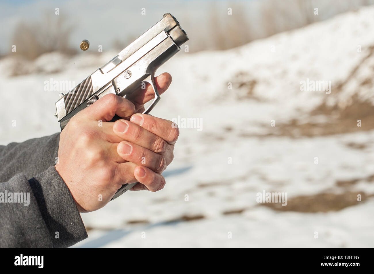 Close-up detail view of shooter hands holding gun and shooting ...