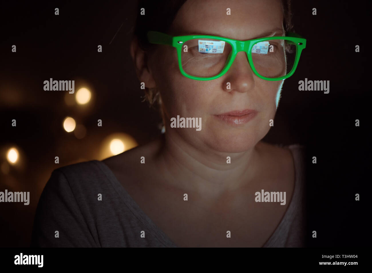 Low key portrait of busy woman working on laptop computer at night from ...