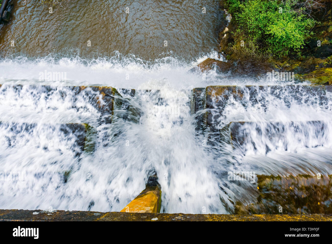 Looking down at the flow of water falling over a concrete dam, San ...