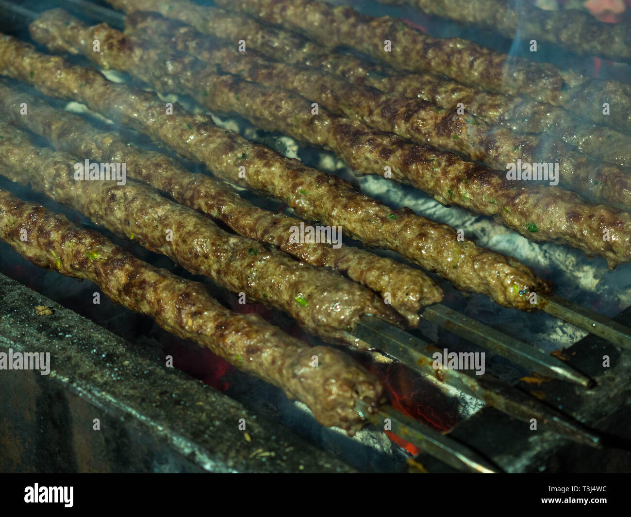 Kebab or kebap on metal skewer barbecue and embers in the kebab ...