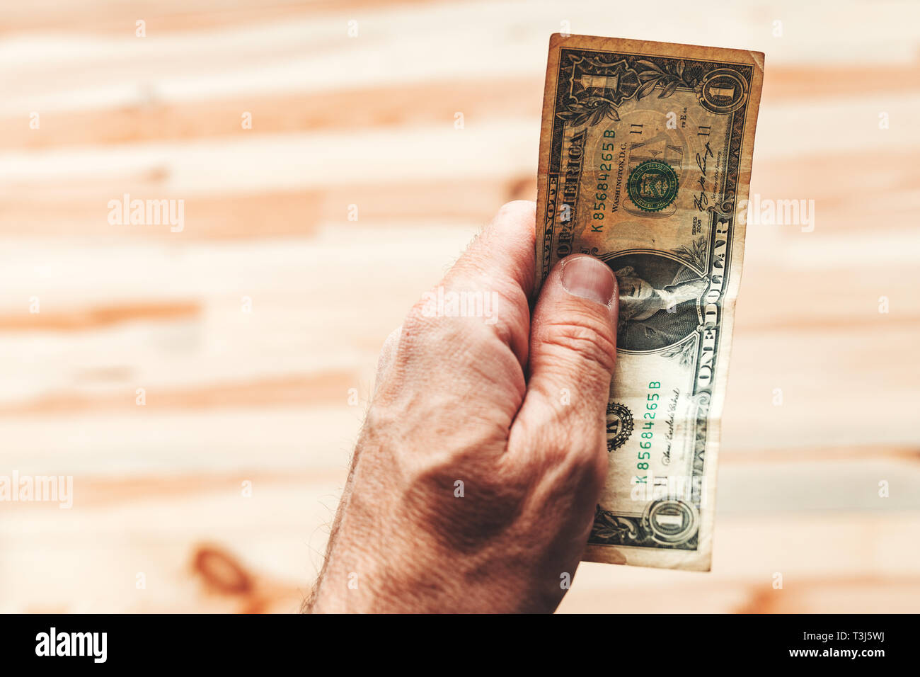 Man paying with one US dollar bill, close up of male hand holding ...