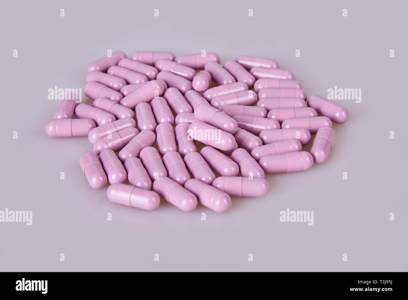 Spilled capsules on the white background. Vitamin supplements tablets ...
