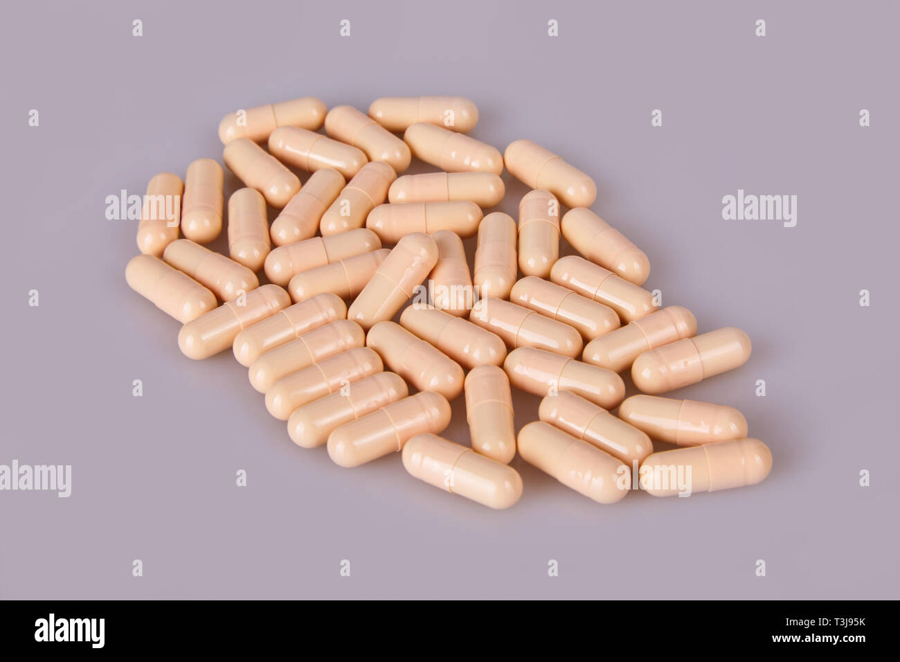 Spilled capsules on the white background. Vitamin supplements tablets ...