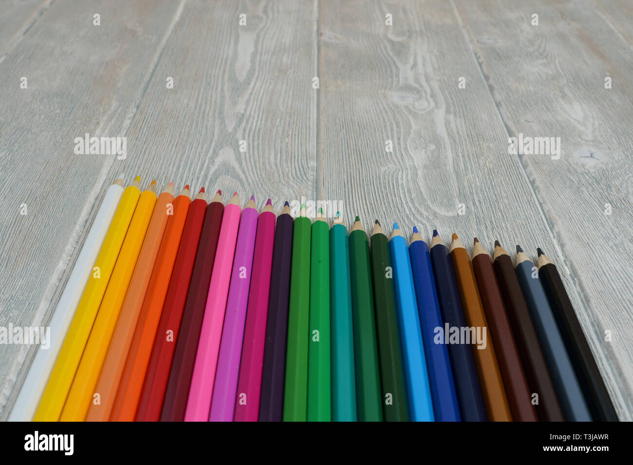 collection of rainbow spectrum color crayons on a white-grey vintage ...