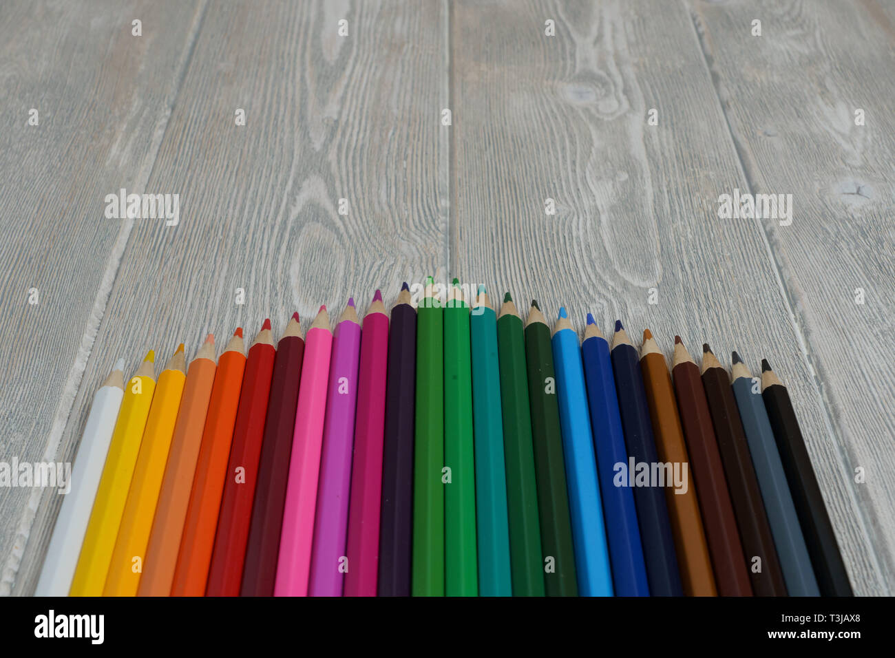 collection of rainbow spectrum color crayons on a white-grey vintage ...