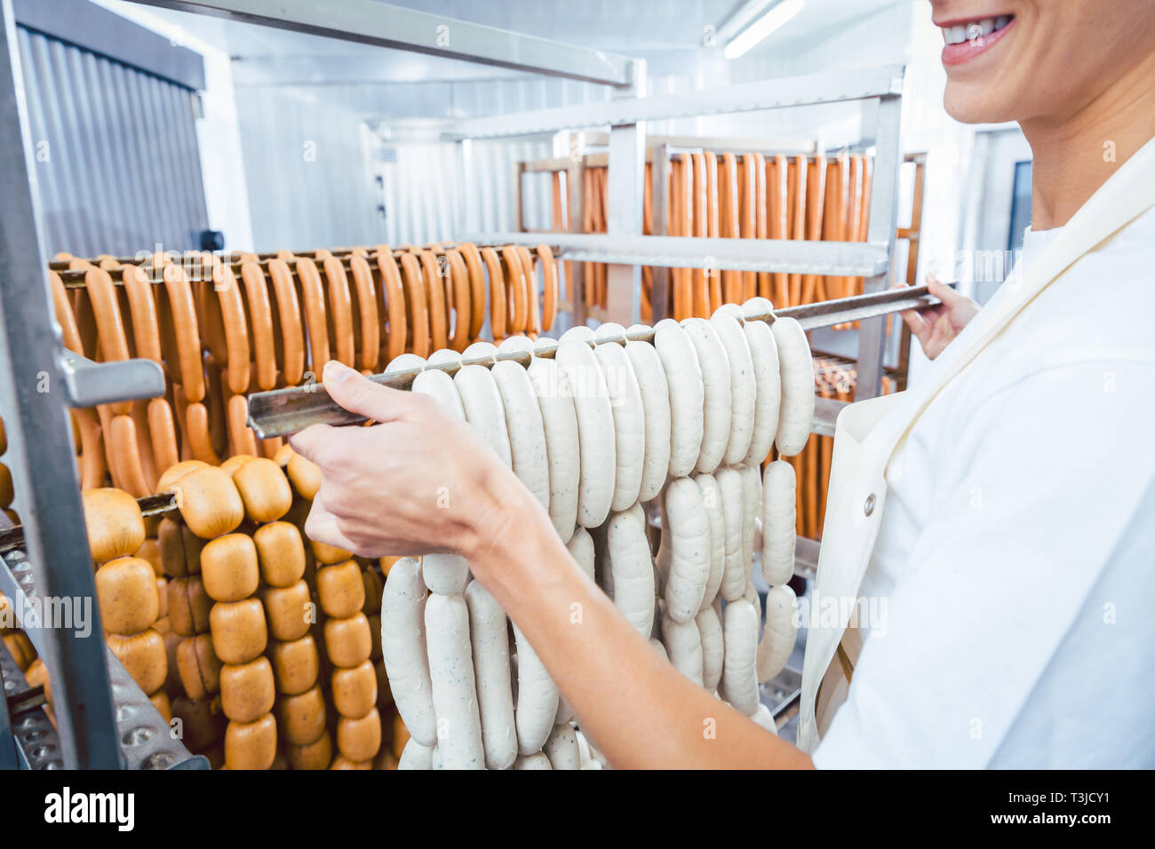 Butcher woman showing sausages on a rail Stock Photo - Alamy