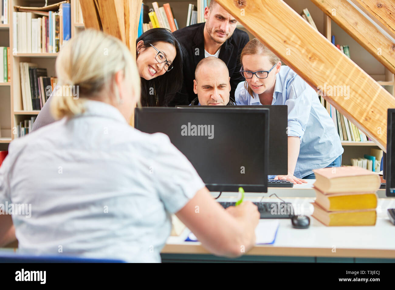 Start-up developer team looks at a computer monitor in the coworking ...