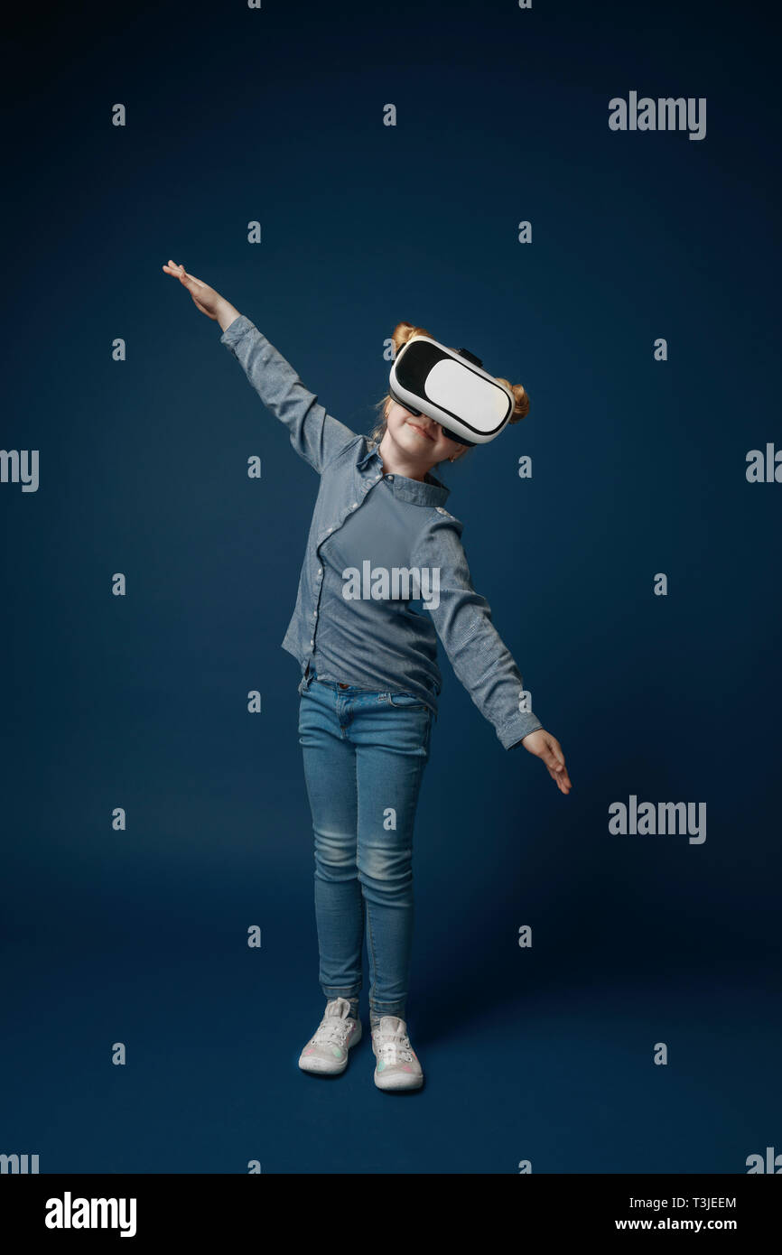 Flying like an aircraft. Little girl or child in jeans and shirt with ...