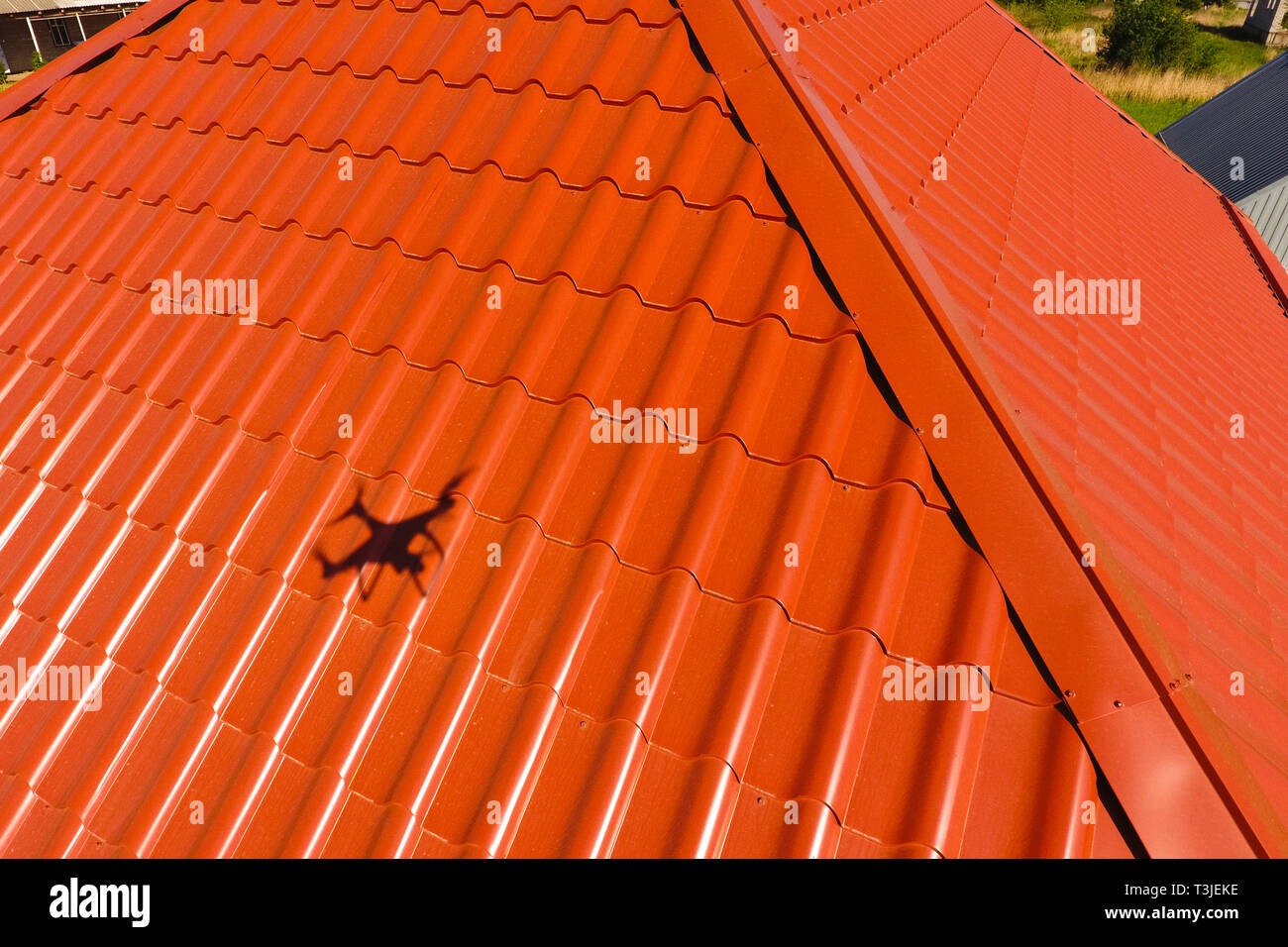 House with an orange roof made of metal, top view. Metallic profile ...