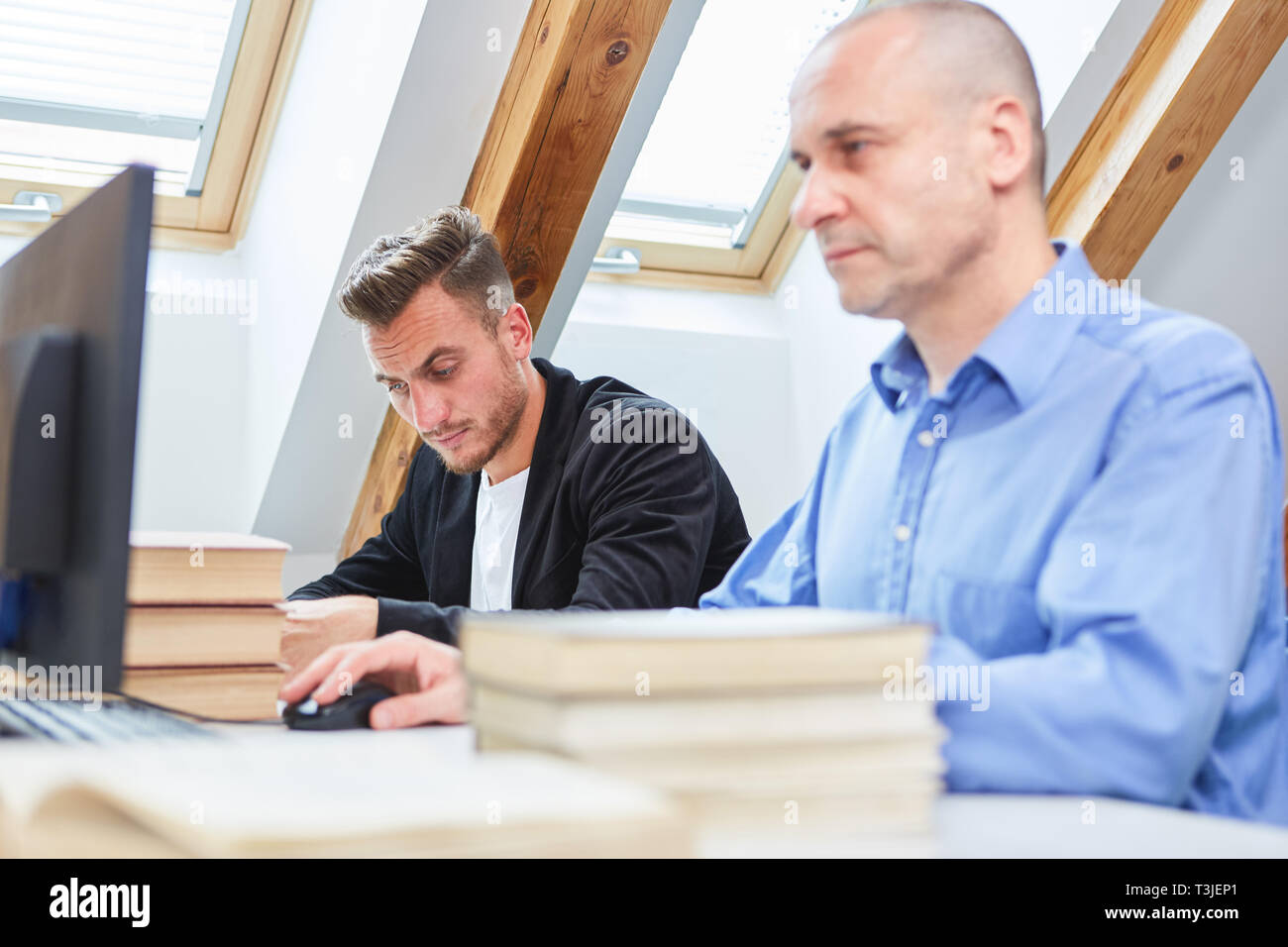 Two men study on the computer or write an exam in the training Stock ...