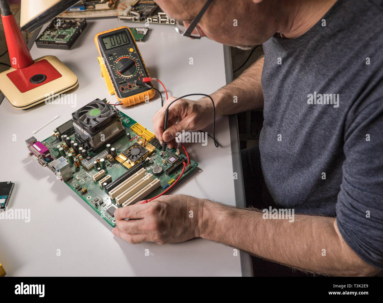 electronics technician is testing a computer chip. PC repair Stock ...