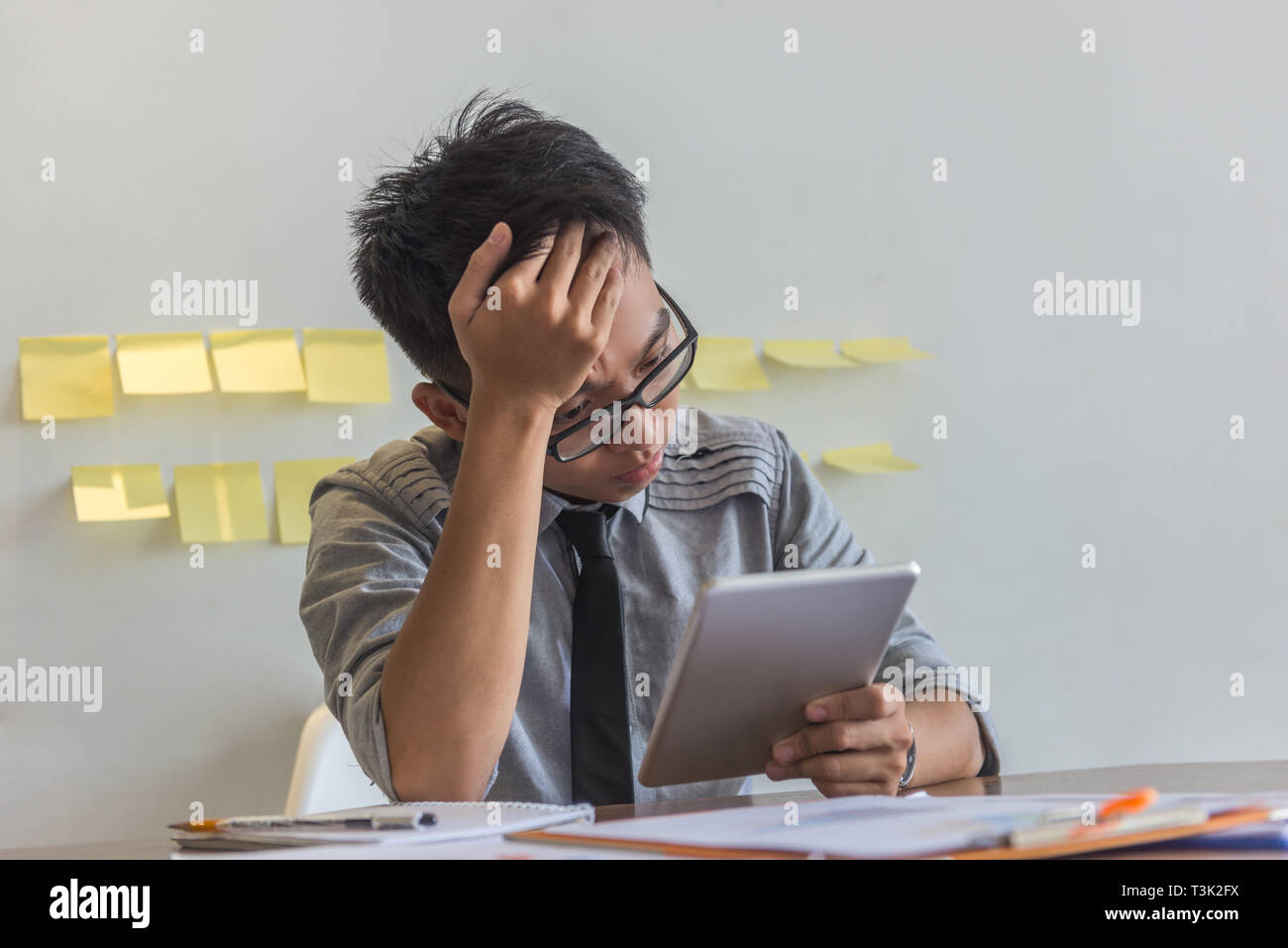 Asian businessman looking at bad financial results on the tablet Stock ...