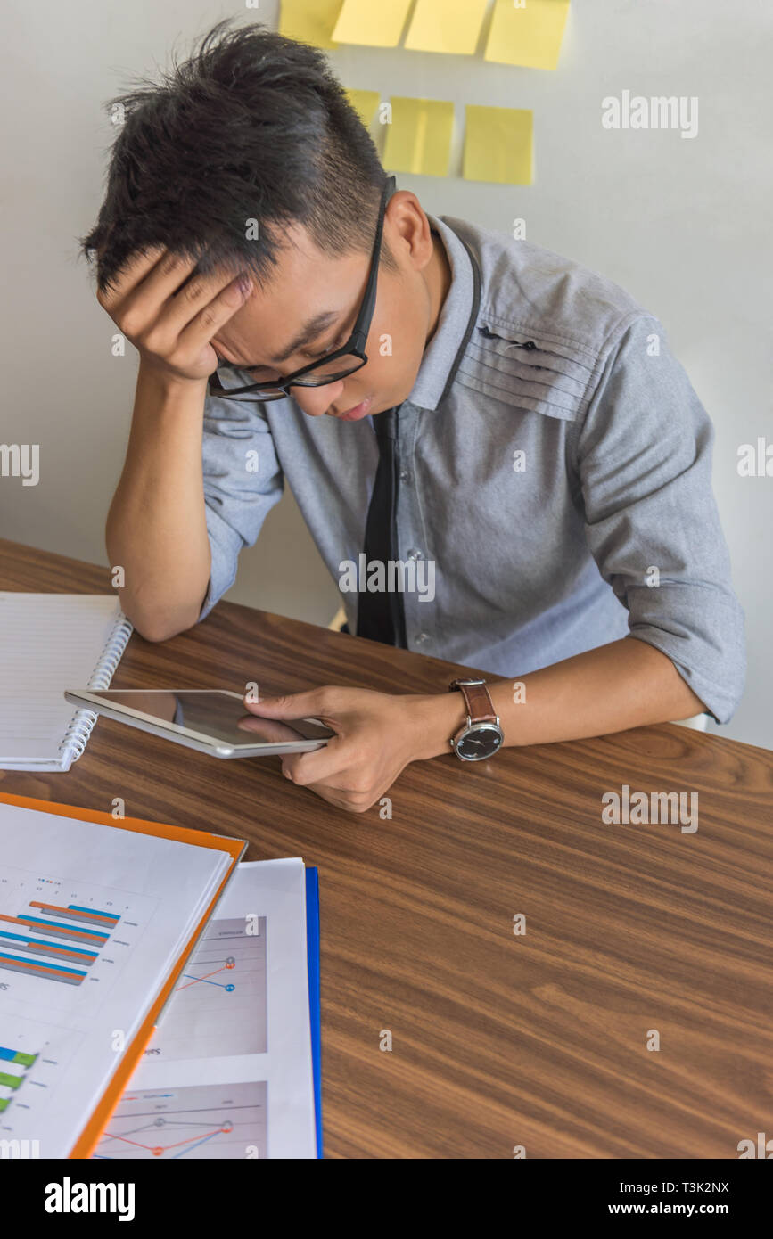 Office man worried about bad financial data on tablet Stock Photo - Alamy