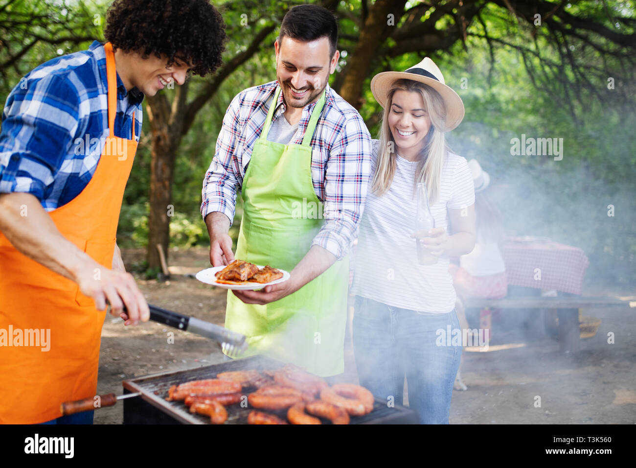 Group of happy friends having a barbecue party in nature Stock Photo ...