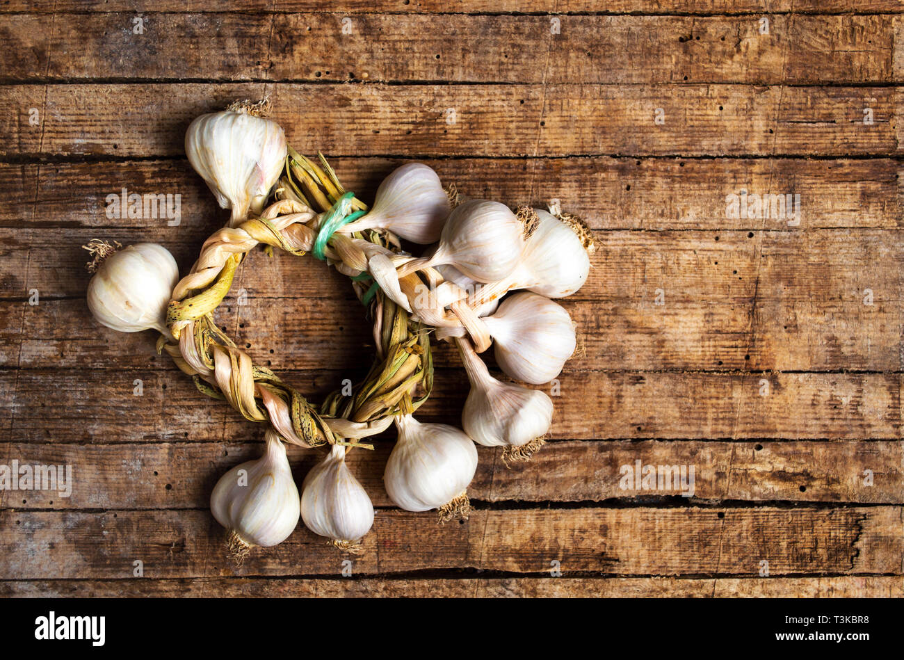 Garlic wreath on a rustic wooden table top view Stock Photo - Alamy