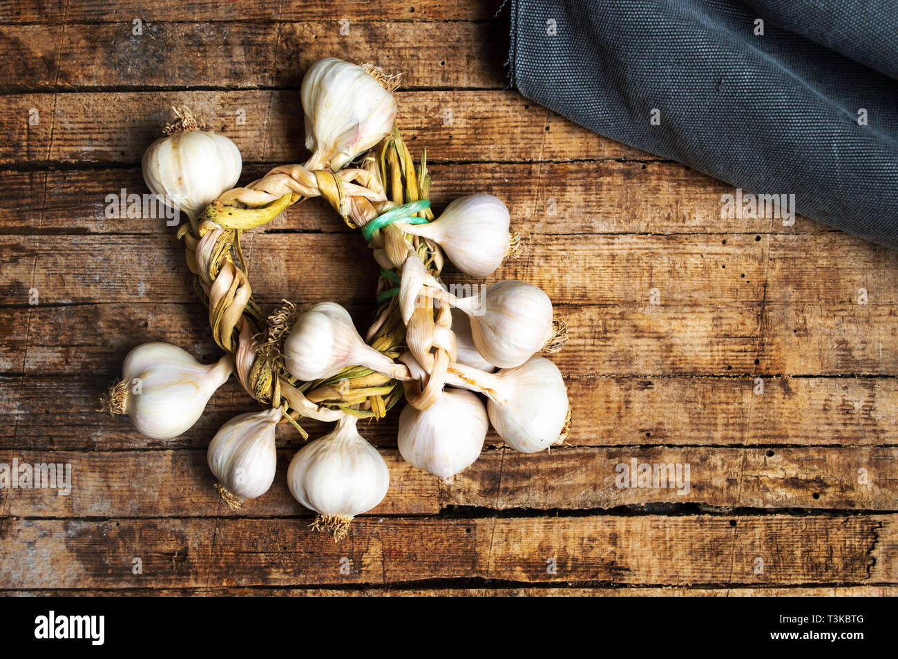 Garlic wreath on a rustic wooden table top view Stock Photo - Alamy