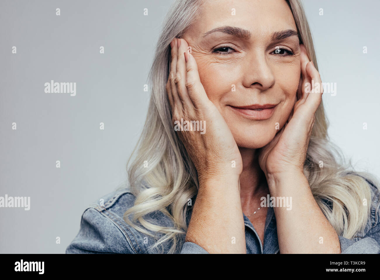 Beautiful elderly woman touching her soft skin. Woman with beautiful ...