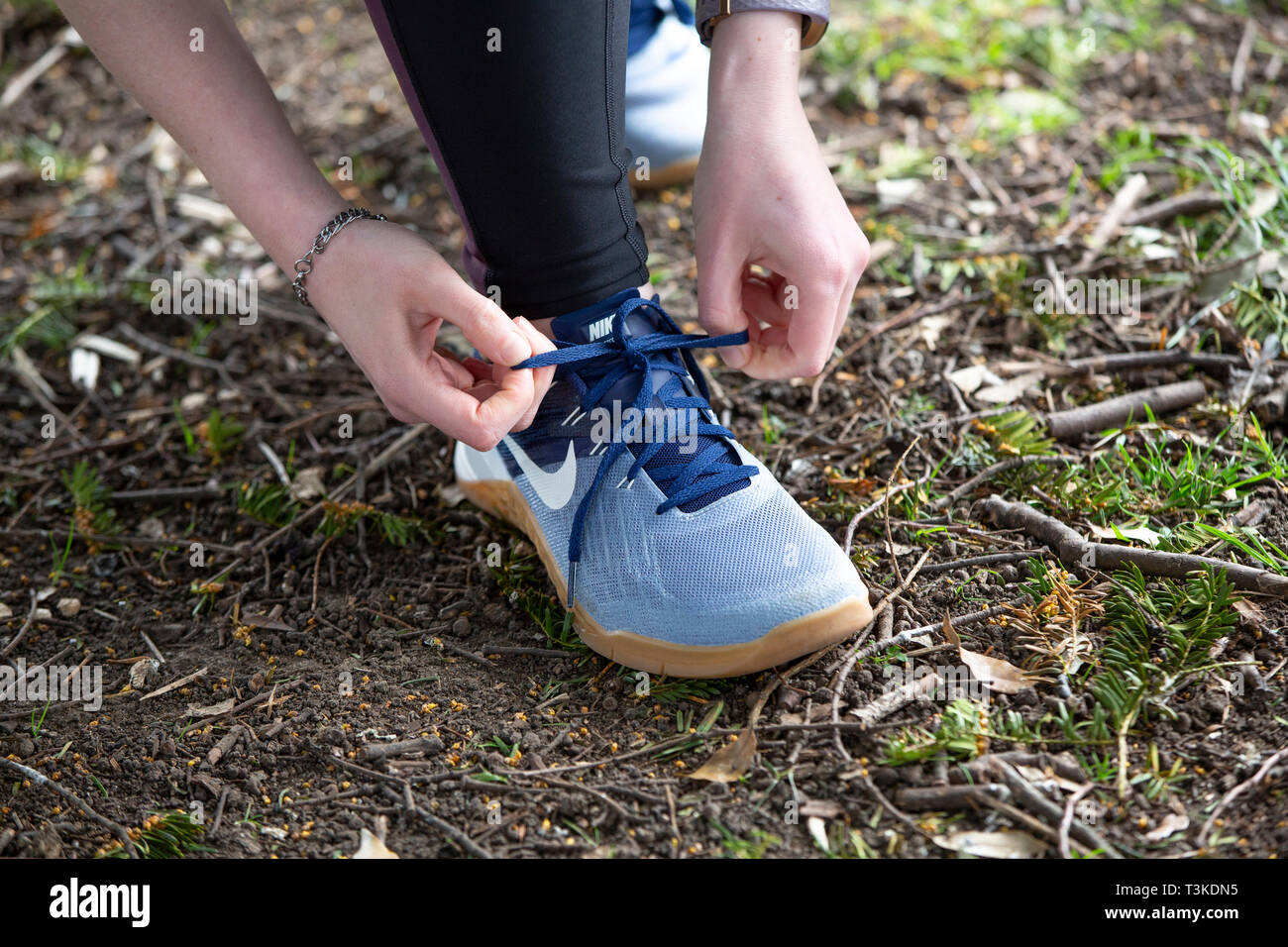 Young woman tying up trainer laces before going for a run Stock Photo ...