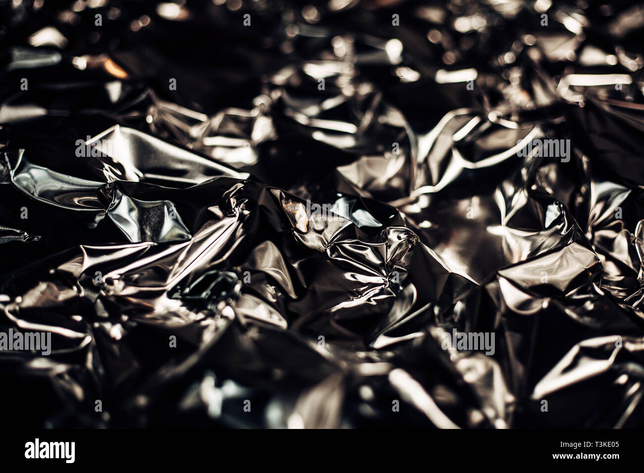 Full frame take of a sheeT of crumpled silver aluminum foil background ...