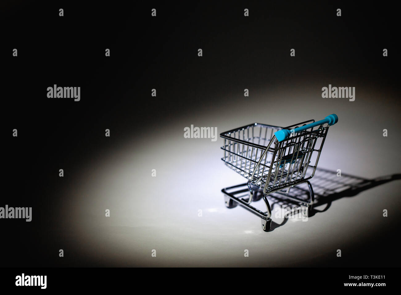 Spotlight and shopping trolley in the dark room. Spotlight effect for ...